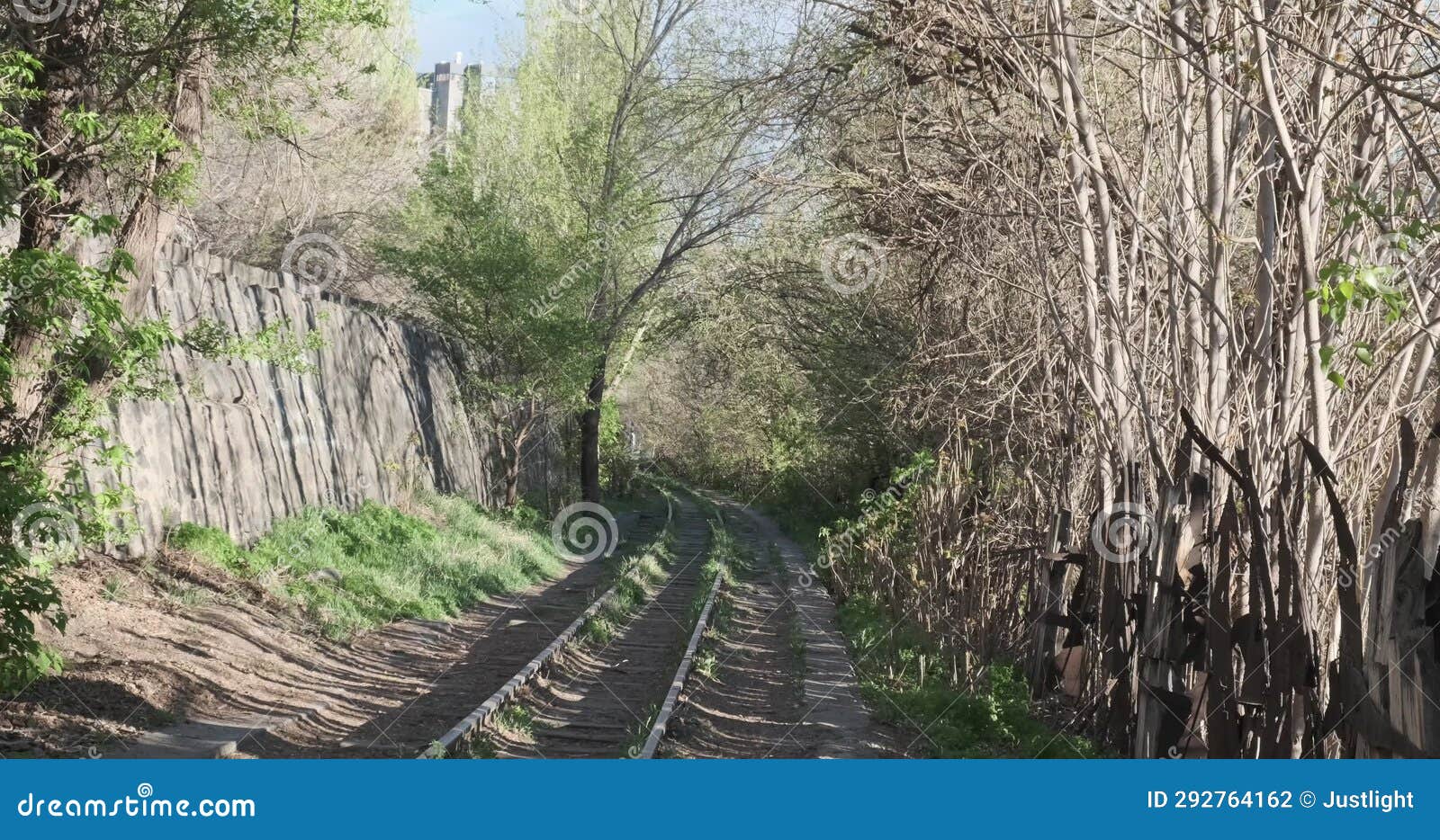 Capture Serene Old Train Tracks between a Hill and Trees, Parallel To a ...