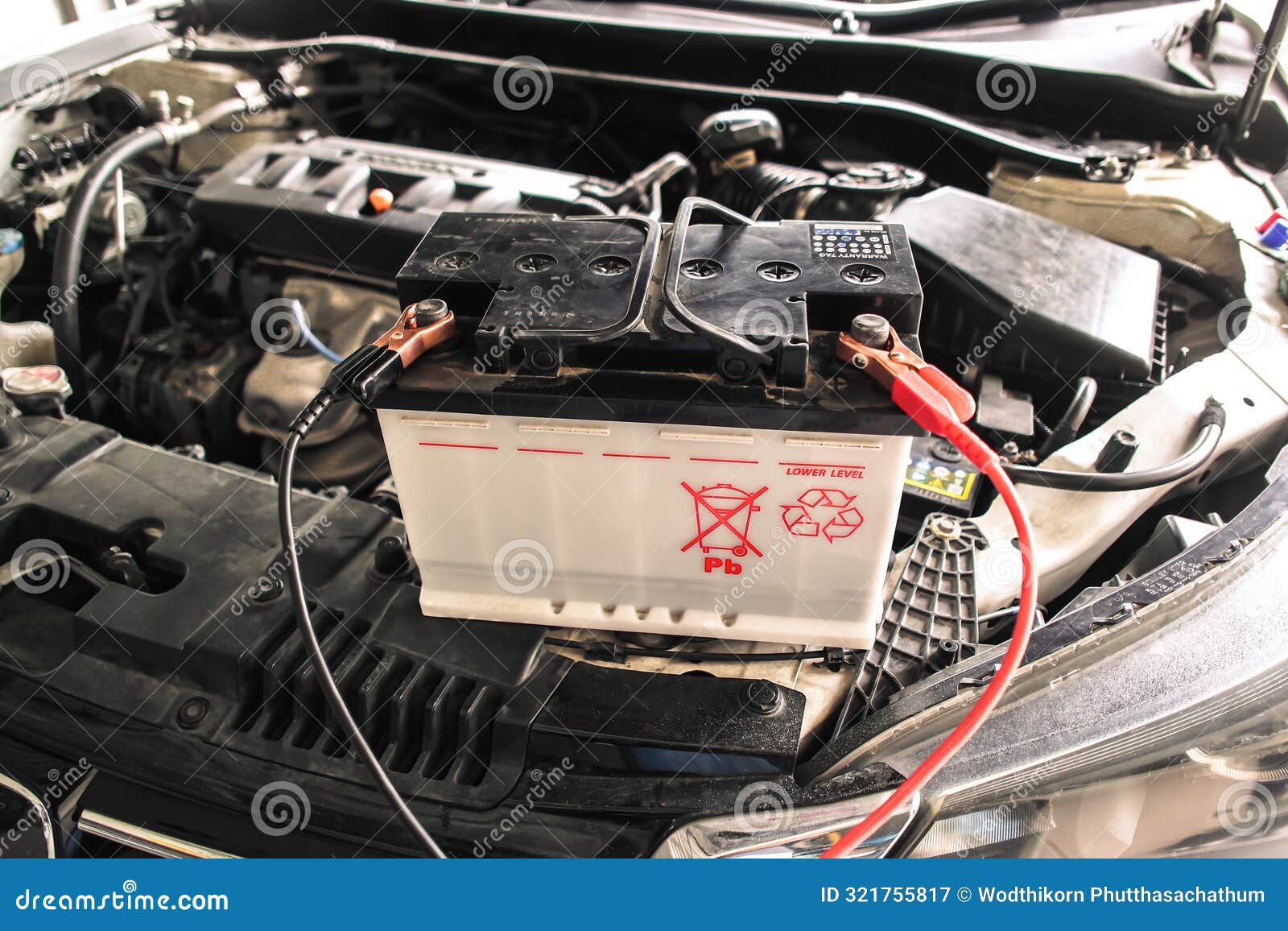 Car Battery Recharge with a Battery Charger in an Engine Compartment ...