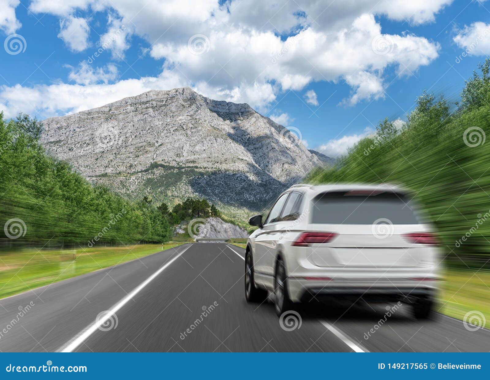 Car Drives Fast on the Highway Against the Backdrop of a Mountain Range ...