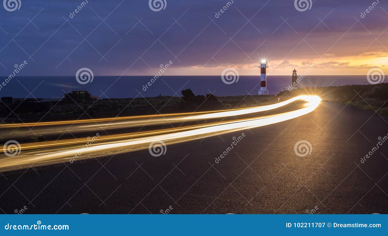 A Car Driving in Front of a Lighthouse at Sunset Stock Image - Image of ...