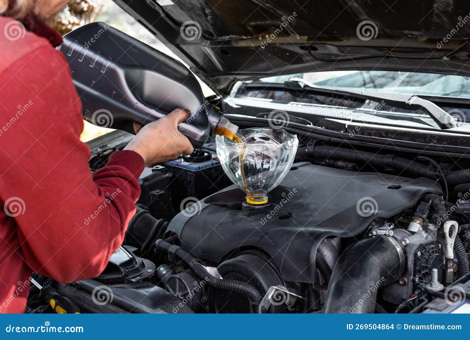 Car Mechanic Pours Engine Oil into the Car Engine through the Funnel ...