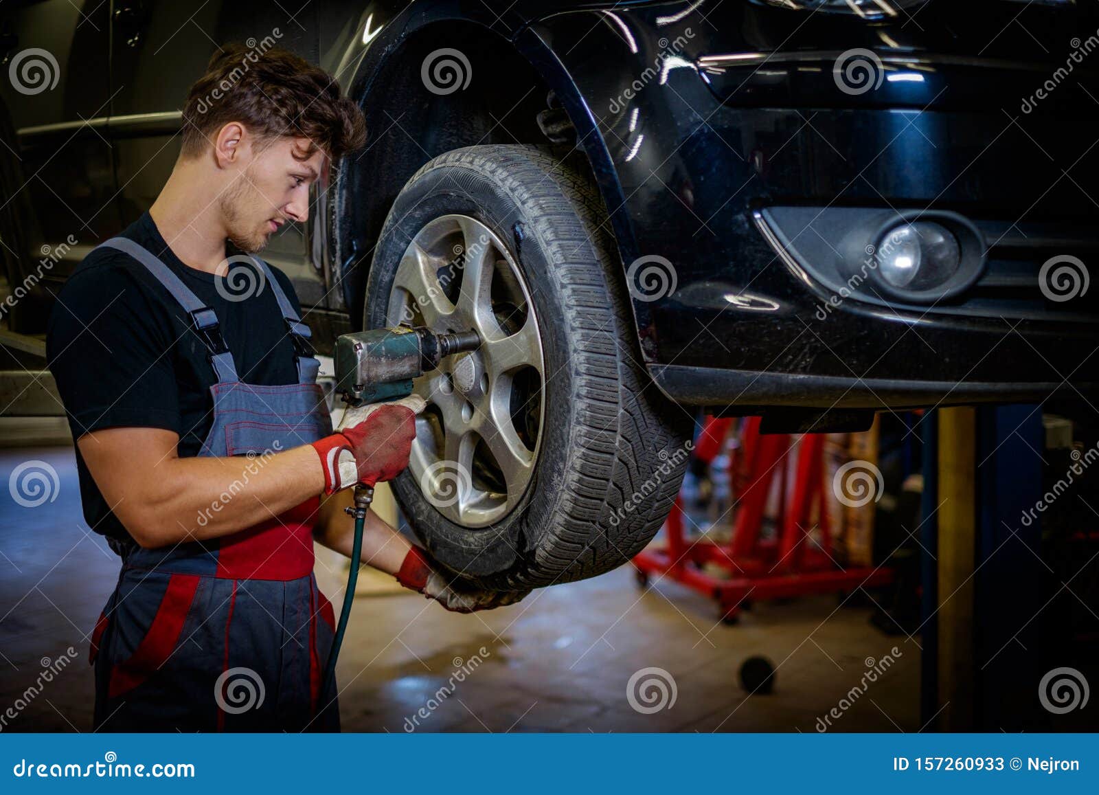 Car Mechanic Replacing Wheel in a Workshop Stock Image - Image of ...