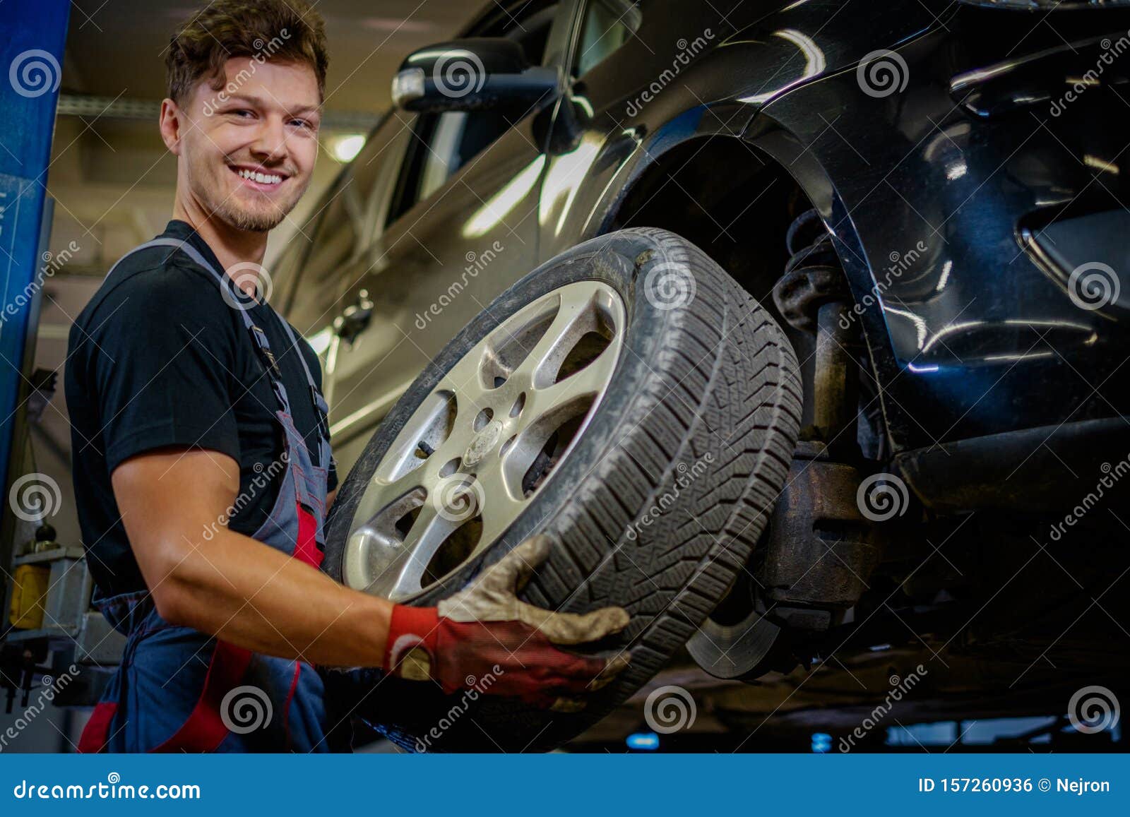 Car Mechanic Replacing Wheel in a Workshop Stock Photo - Image of check ...