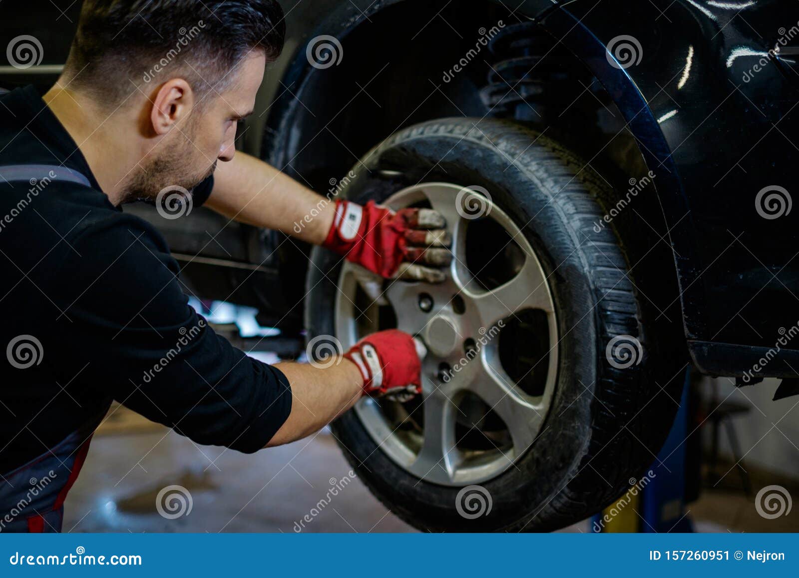 Car Mechanic Replacing Wheel in a Workshop Stock Image - Image of ...