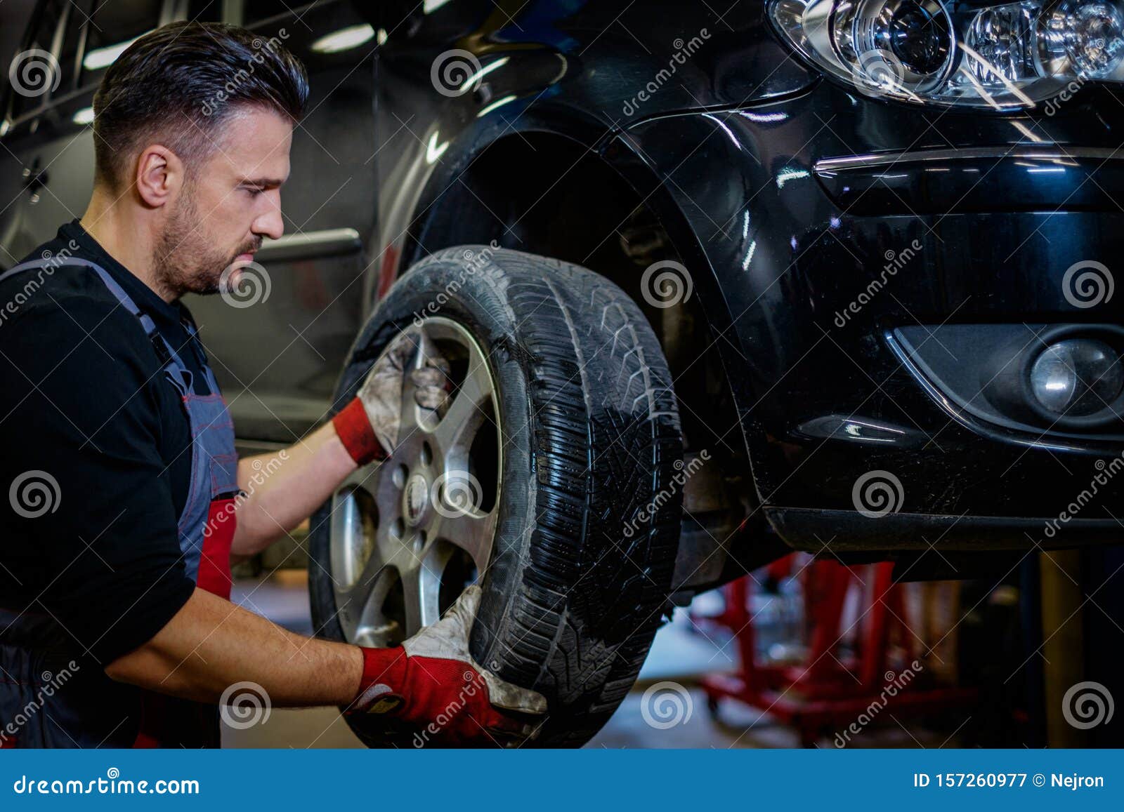 Car Mechanic Replacing Wheel in a Workshop Stock Image - Image of mount ...