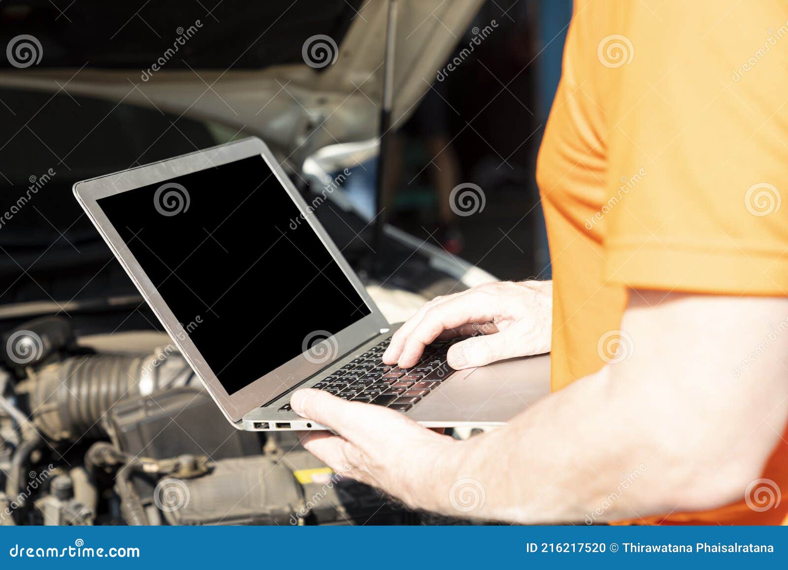 A Car Mechanic is Using a Laptop Computer To Check the Engine Operation ...
