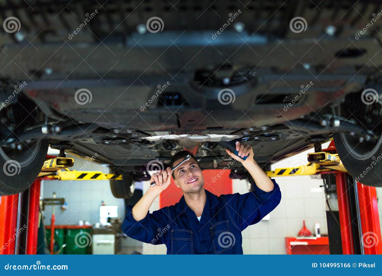 Car Mechanic Working on the Underside of a Car Stock Photo - Image of ...