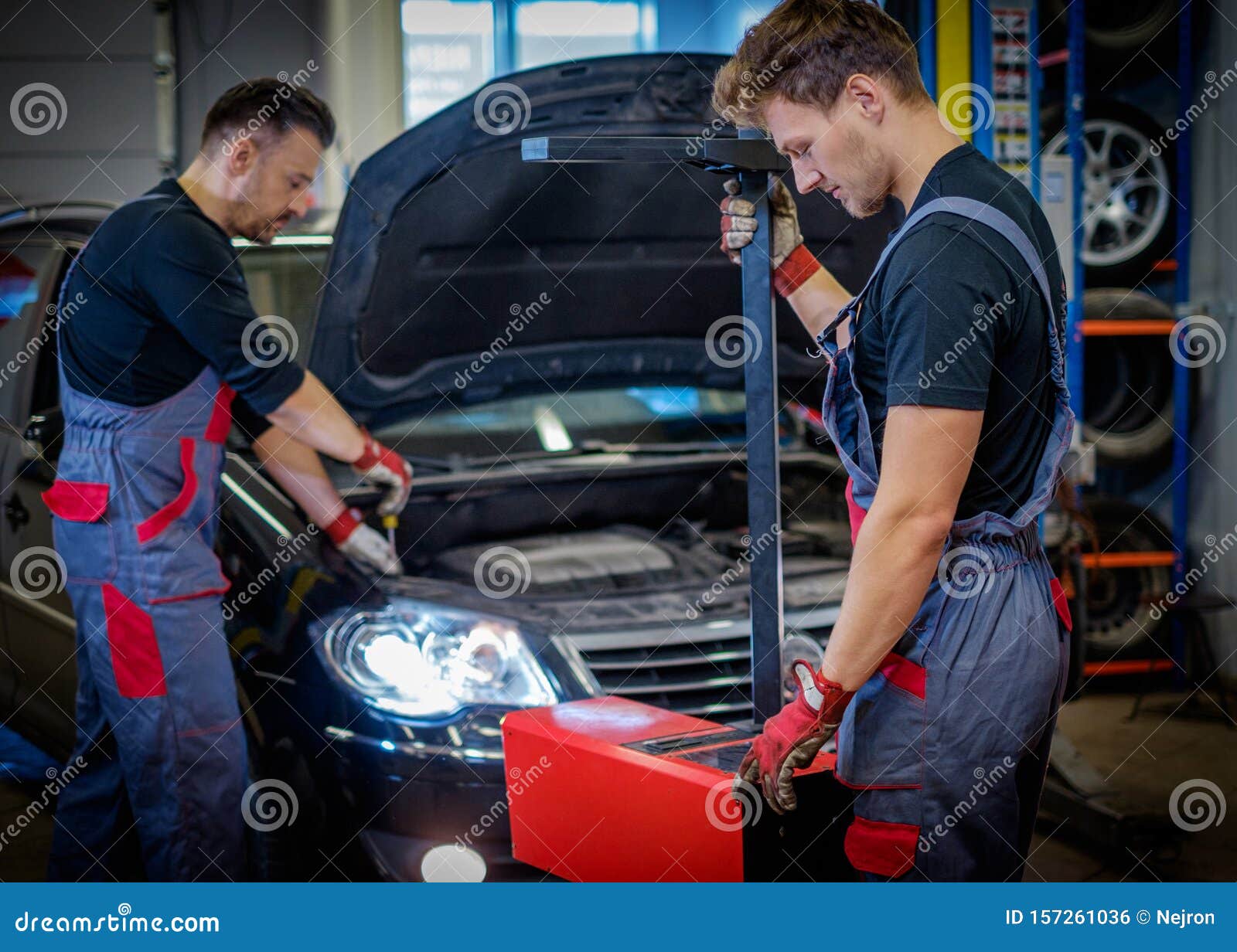 Car Mechanics Inspecting Headlights in a Workshop Stock Photo - Image ...