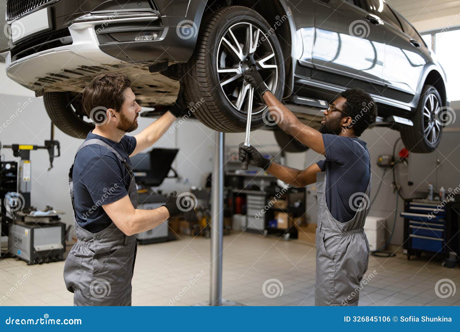 Car Mechanics Working on Vehicle Maintenance in Modern Garage Stock ...