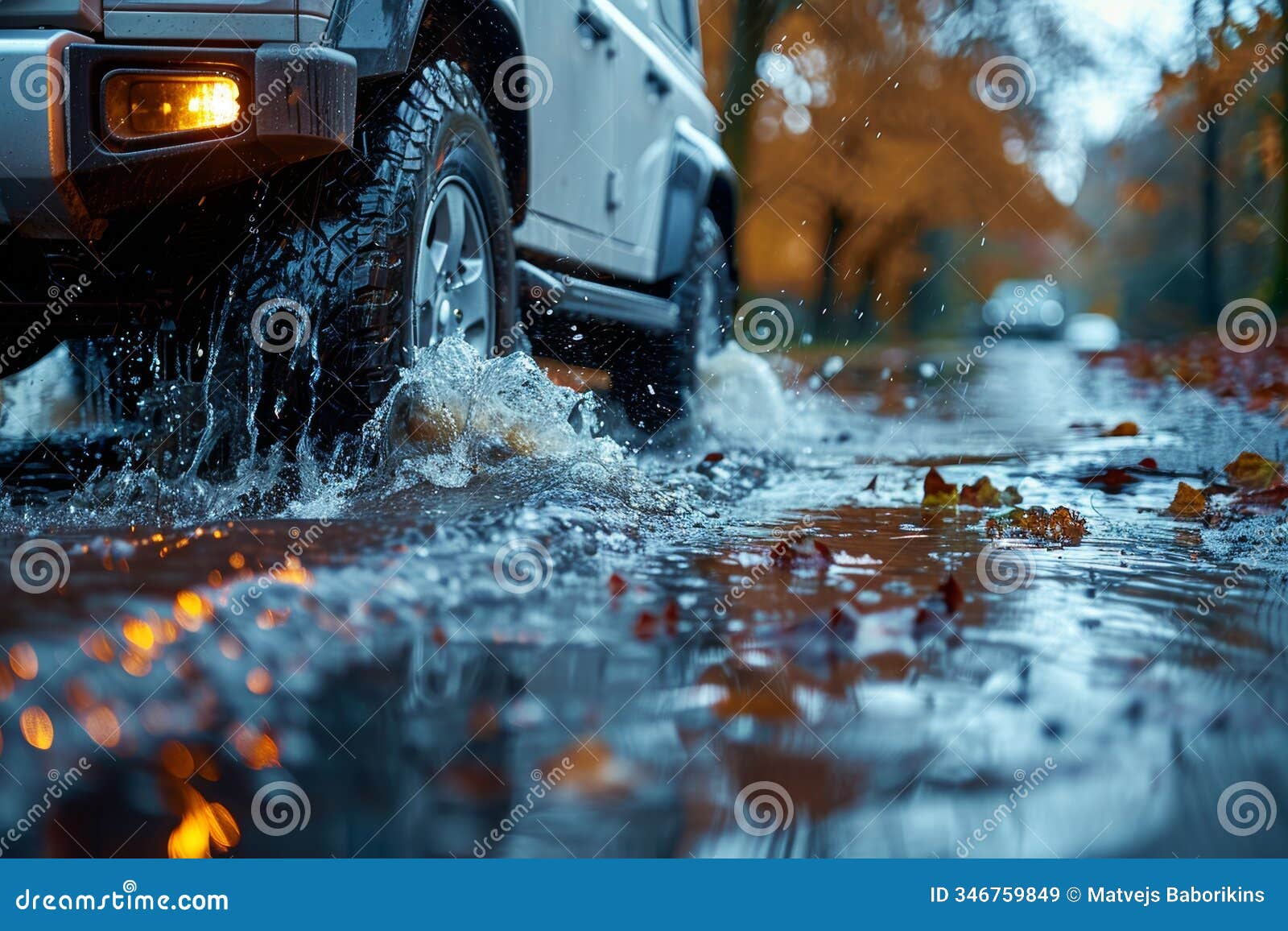 Car Navigating a Deep Puddle, Water Splashing Around the Wheels As it ...