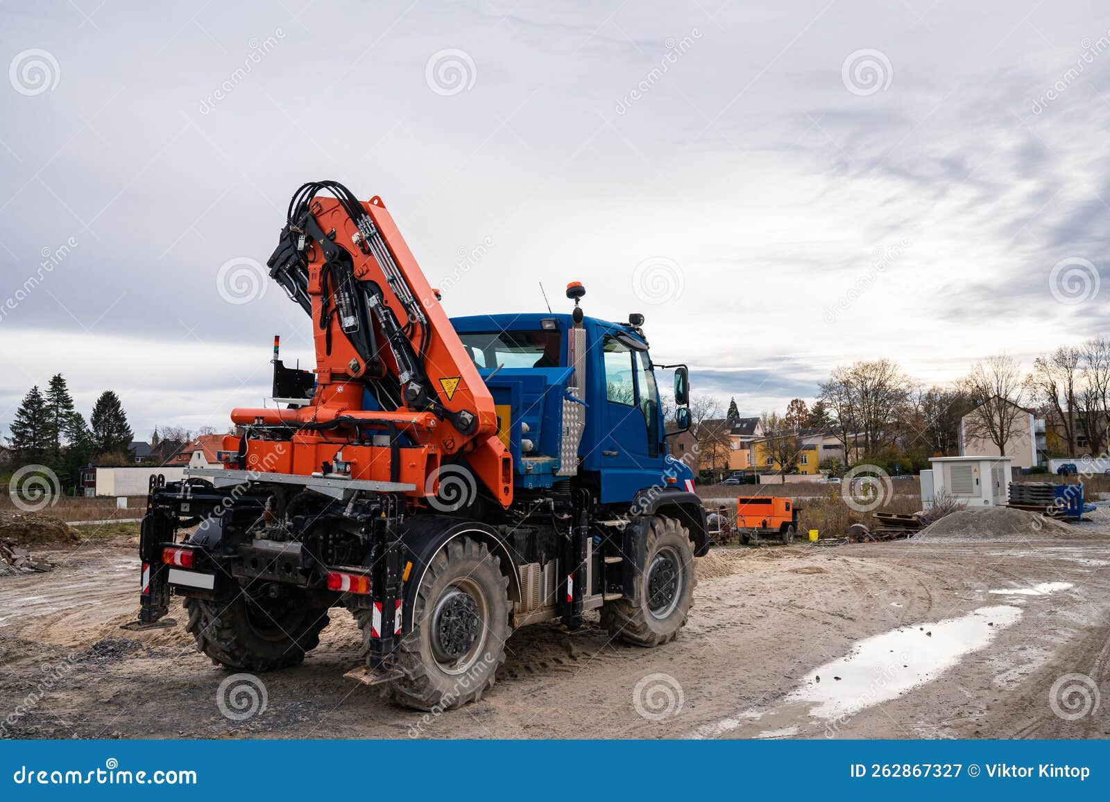 A Car with an Orange Manipulator Crane is Standing on a Construction ...