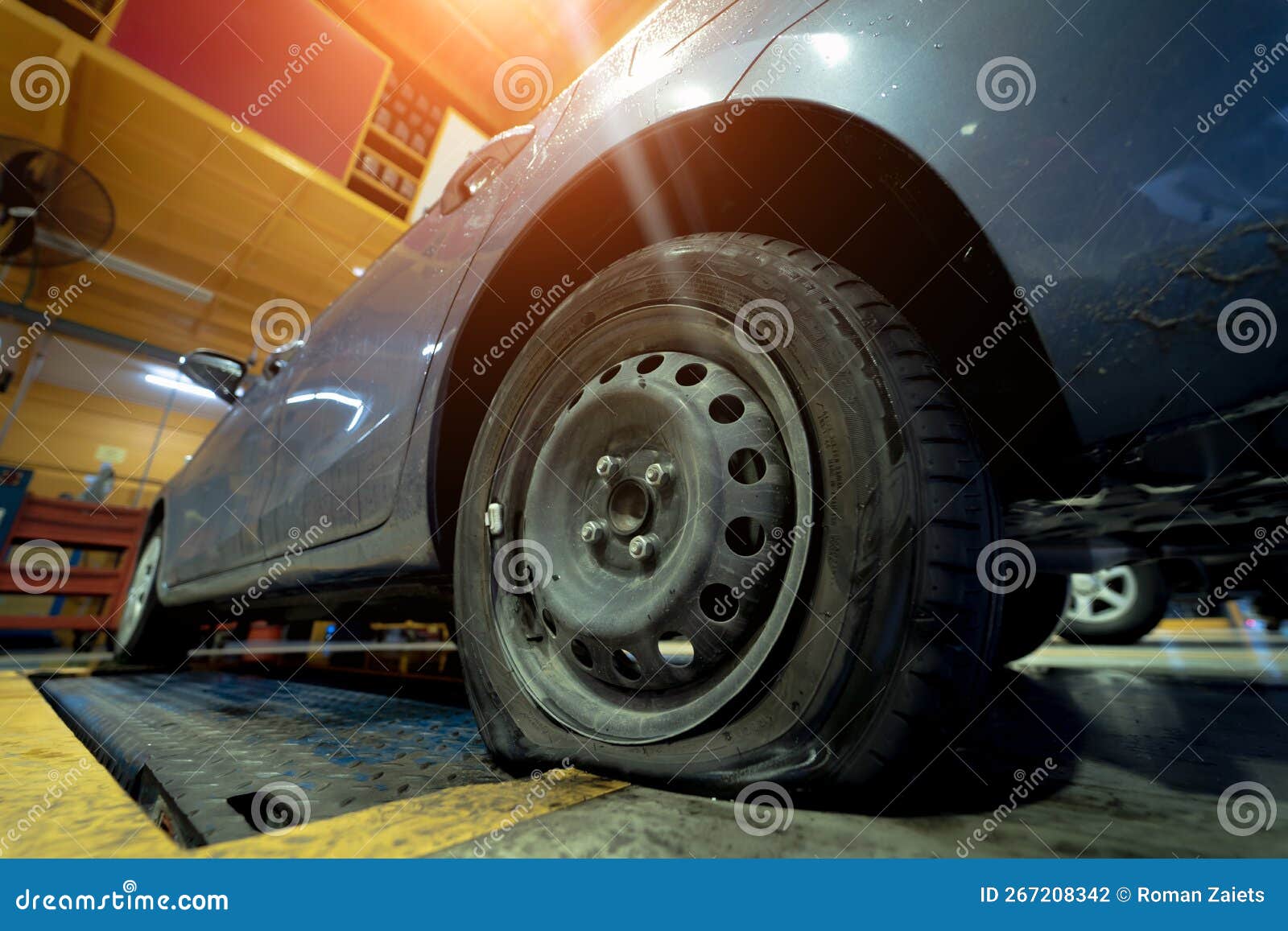 Car with a Punctured and Broken Wheel in a Car Repair Shop Stock Photo ...