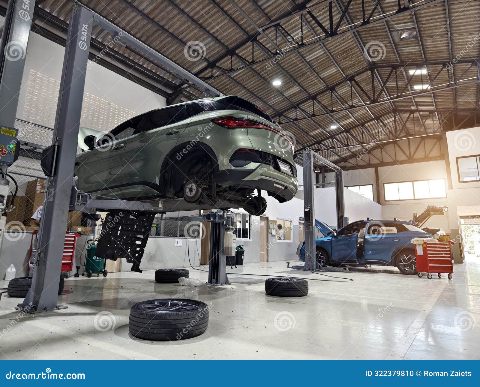 A Car is Raised Up Using a Lift Inside a Service for Maintenance Stock ...