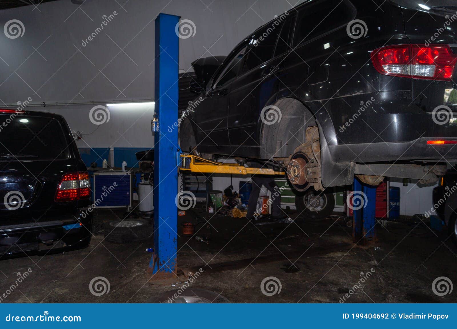 Car Repair in the Box on the Lift with a Hand Tool Stock Photo - Image ...