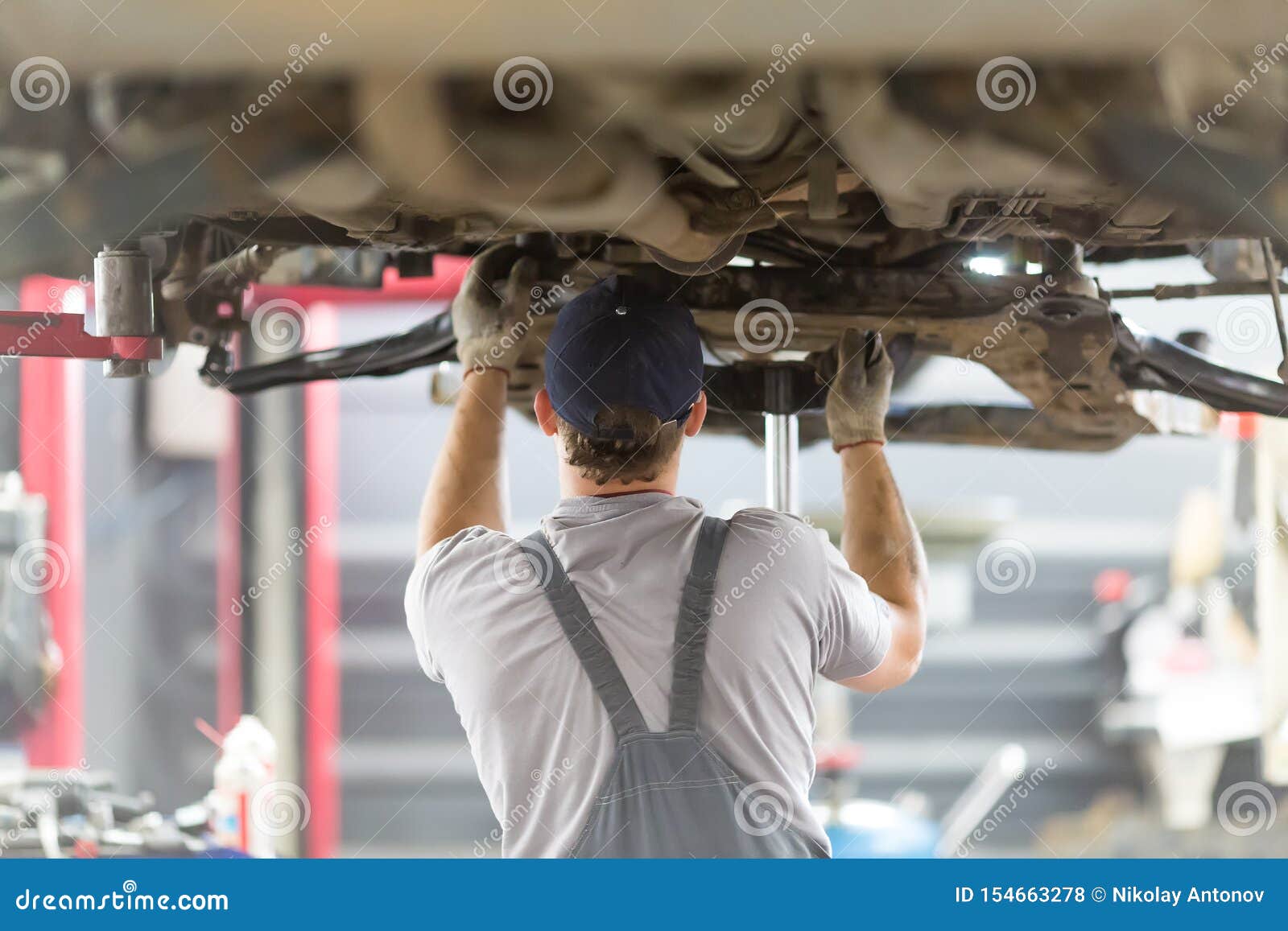 Car Repair Service. Mechanic Working with a Car in Mechanical Workshop ...