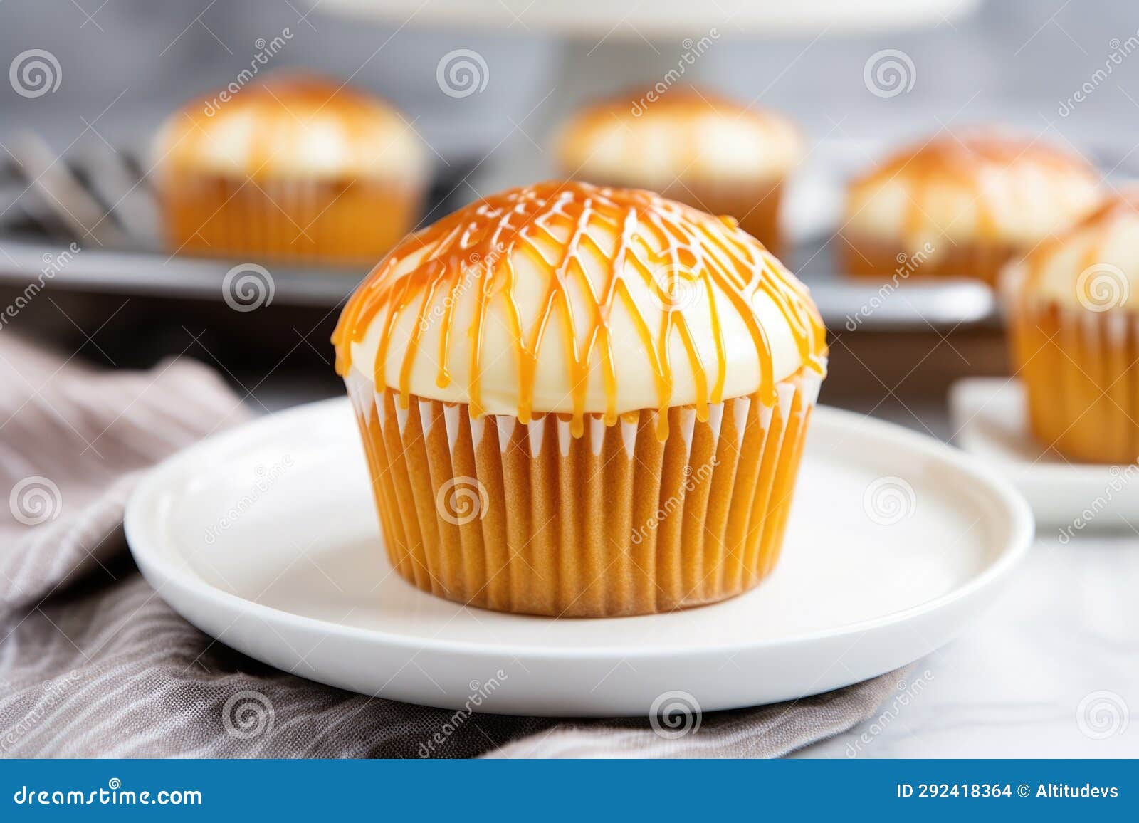 A Caramel-filled Vanilla Cupcake with Caramel Drizzle on Glass Dish ...
