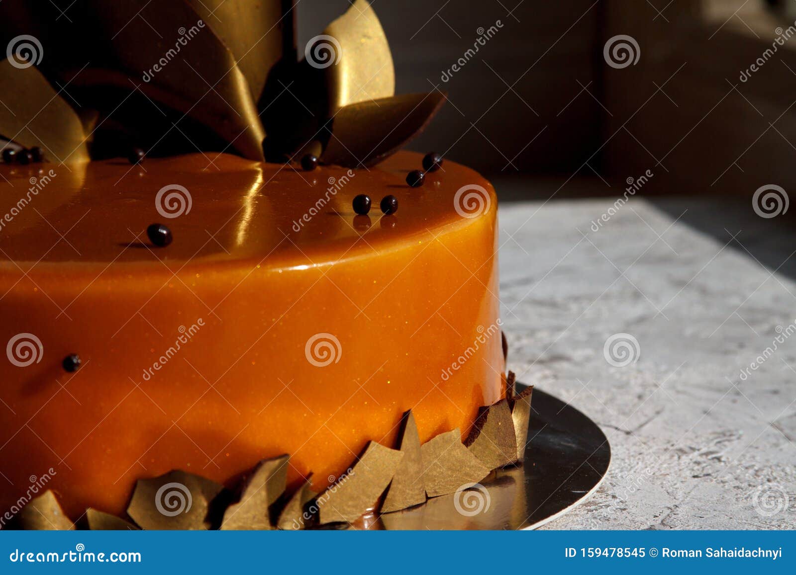 Caramel Icing Cake Decorated with Gold Foil and Chocolate Drops on a ...