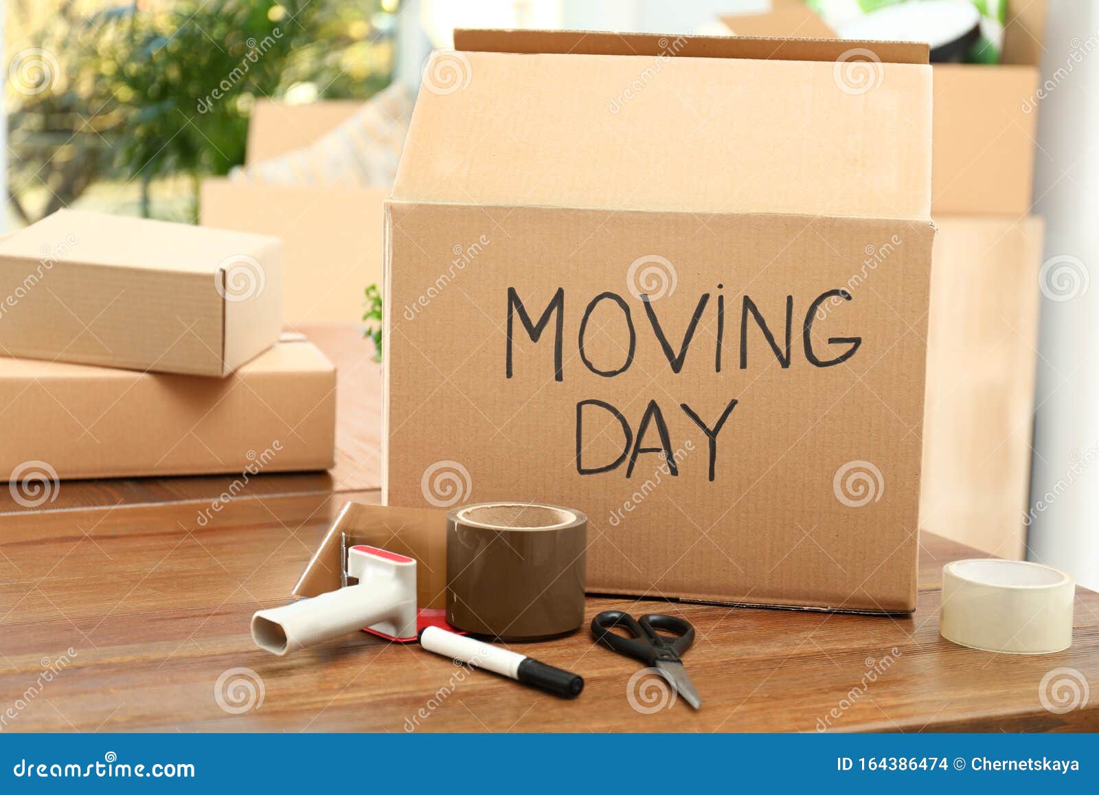 Cardboard Box with Words MOVING DAY and Packaging Items on Table Stock ...