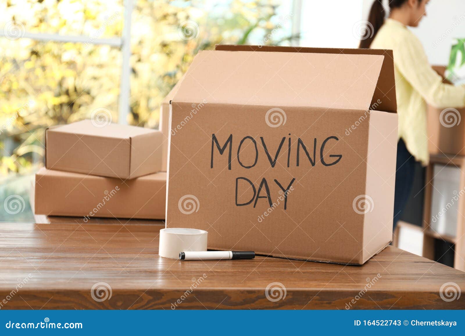 Cardboard Box with Words MOVING DAY and Packaging Items on Table Stock ...