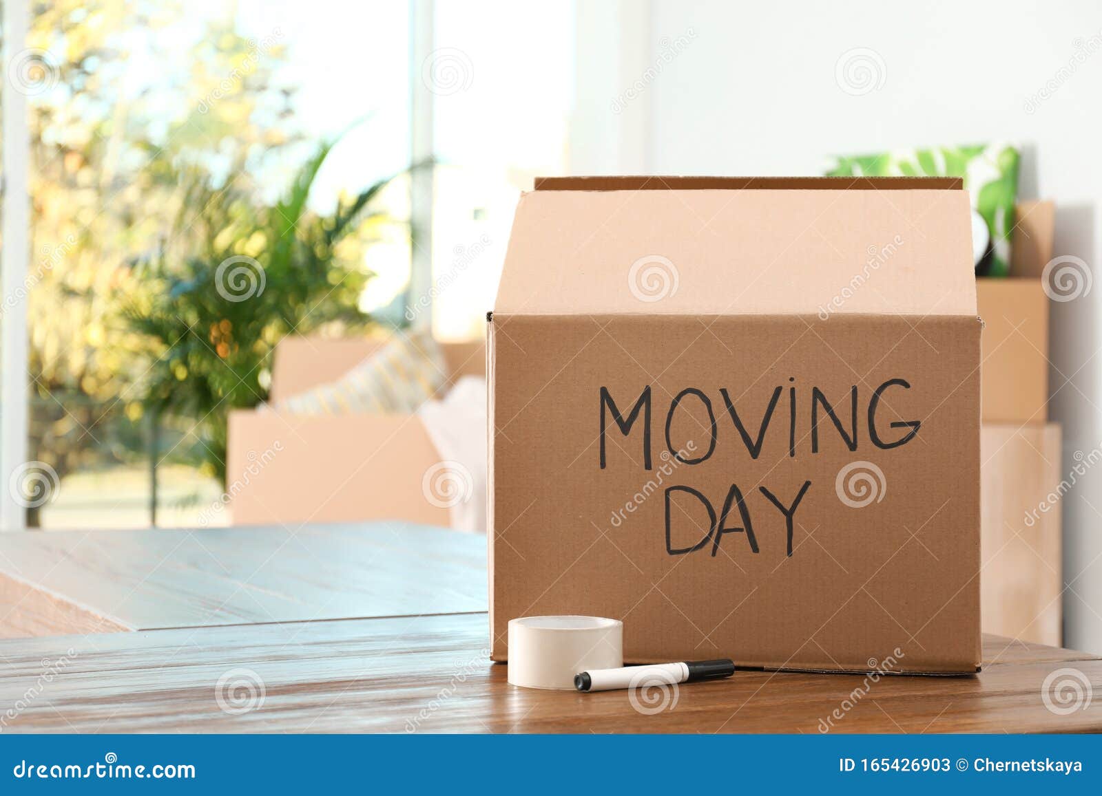 Cardboard Box with Words MOVING DAY and Packaging Items on Table Stock ...