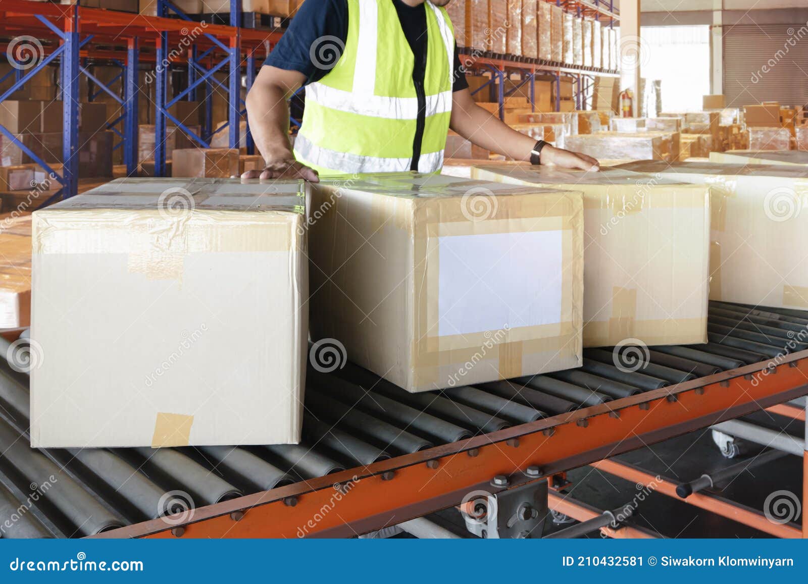 Cardboard Boxes Sorting on Rollers Conveyor Belt. Worker Moving Boxes ...