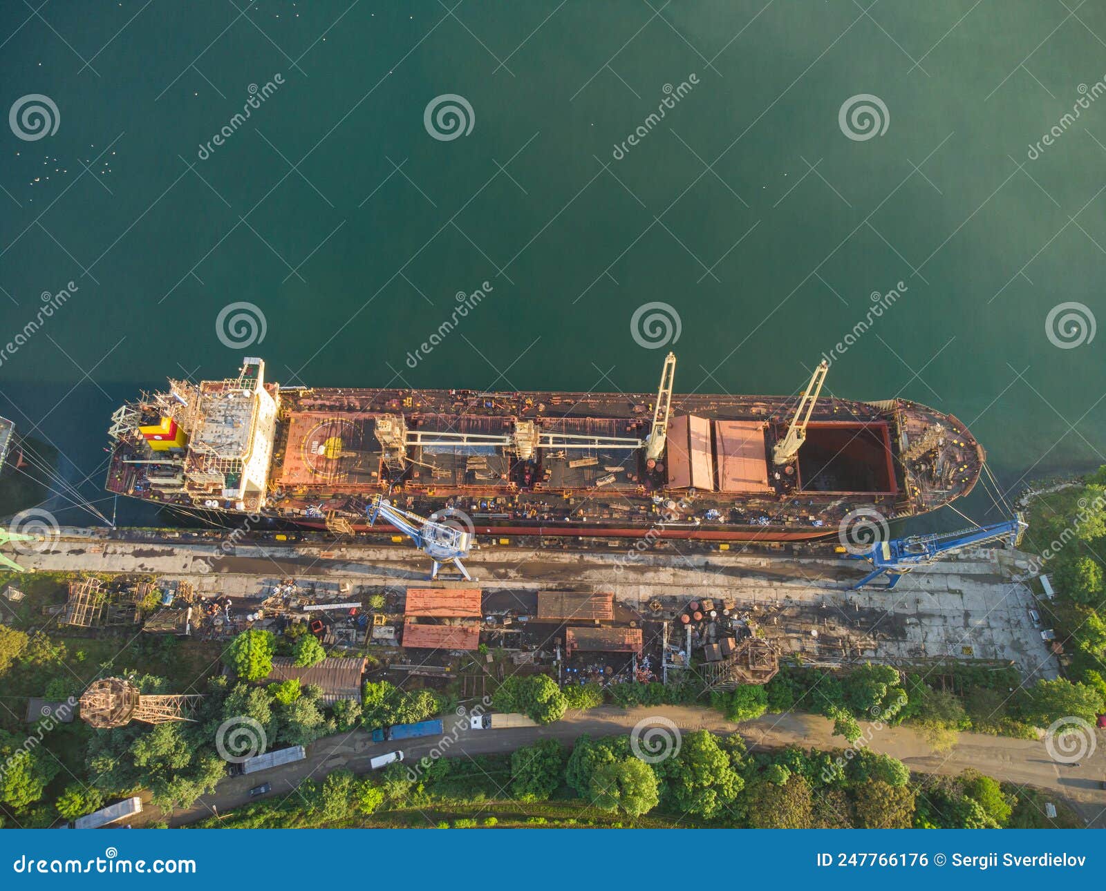 Cargo Ship Unloading in Port at Sunset Stock Photo - Image of crane ...