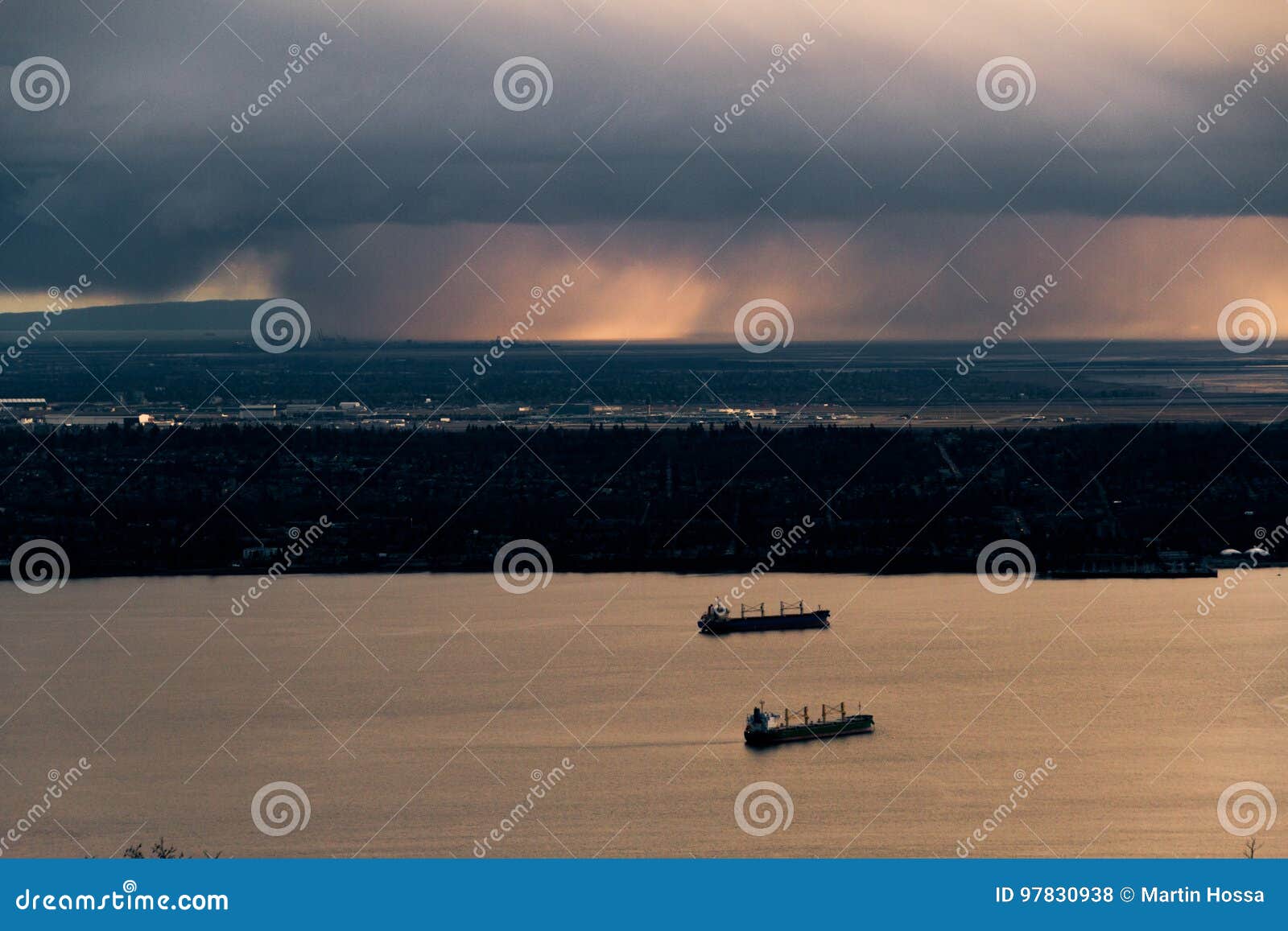 Cargo Ships on Water with Rainy Clouds in the Background Stock Photo ...