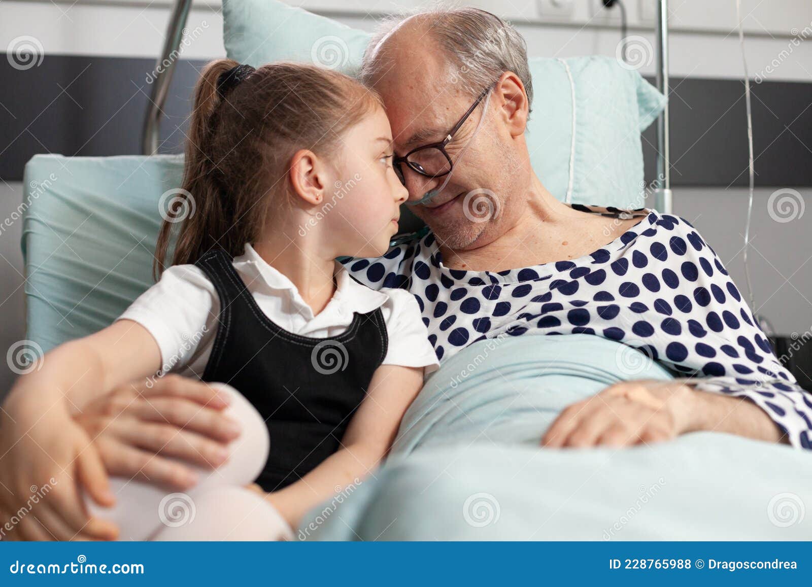 Caring Cheerful Granddaughter Touching Forehead With Sick Elderly
