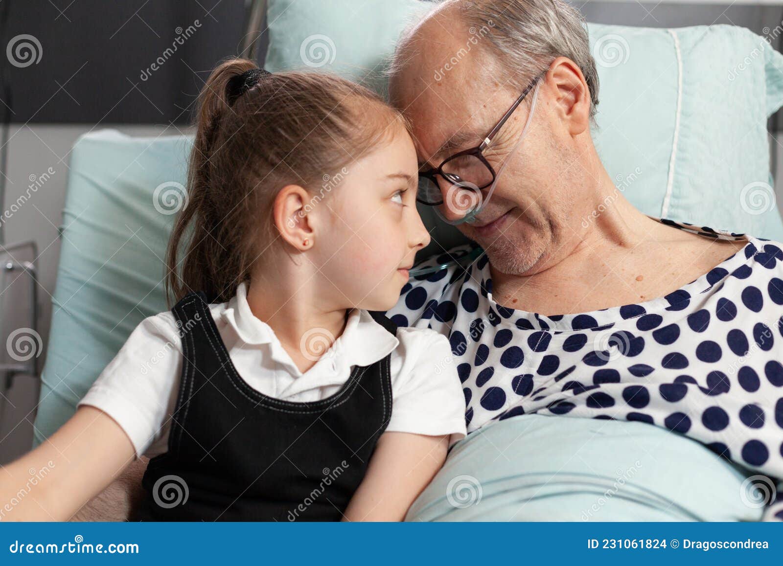 Caring Cheerful Granddaughter Touching Forehead With Sick Elderly
