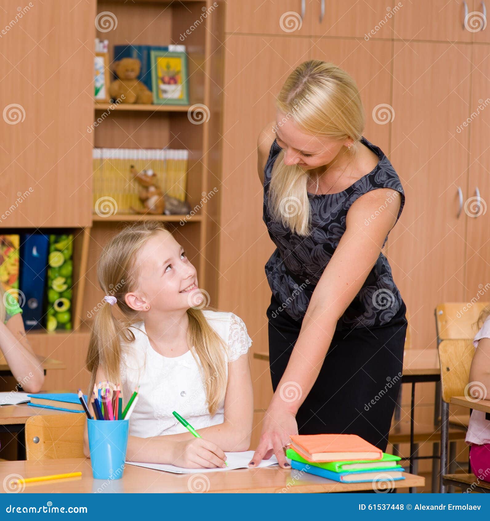 Caring Elementary School Teacher Helping Student in Classroom Stock ...