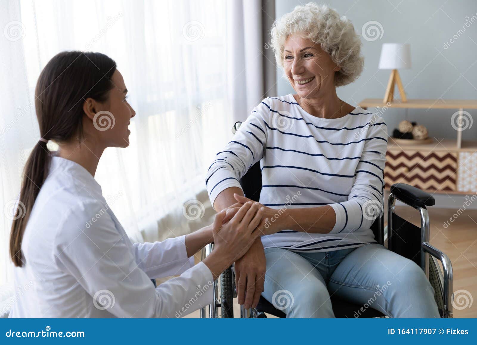 Caring Female Nurse Support Disabled Elder Woman Patient On Wheelchair