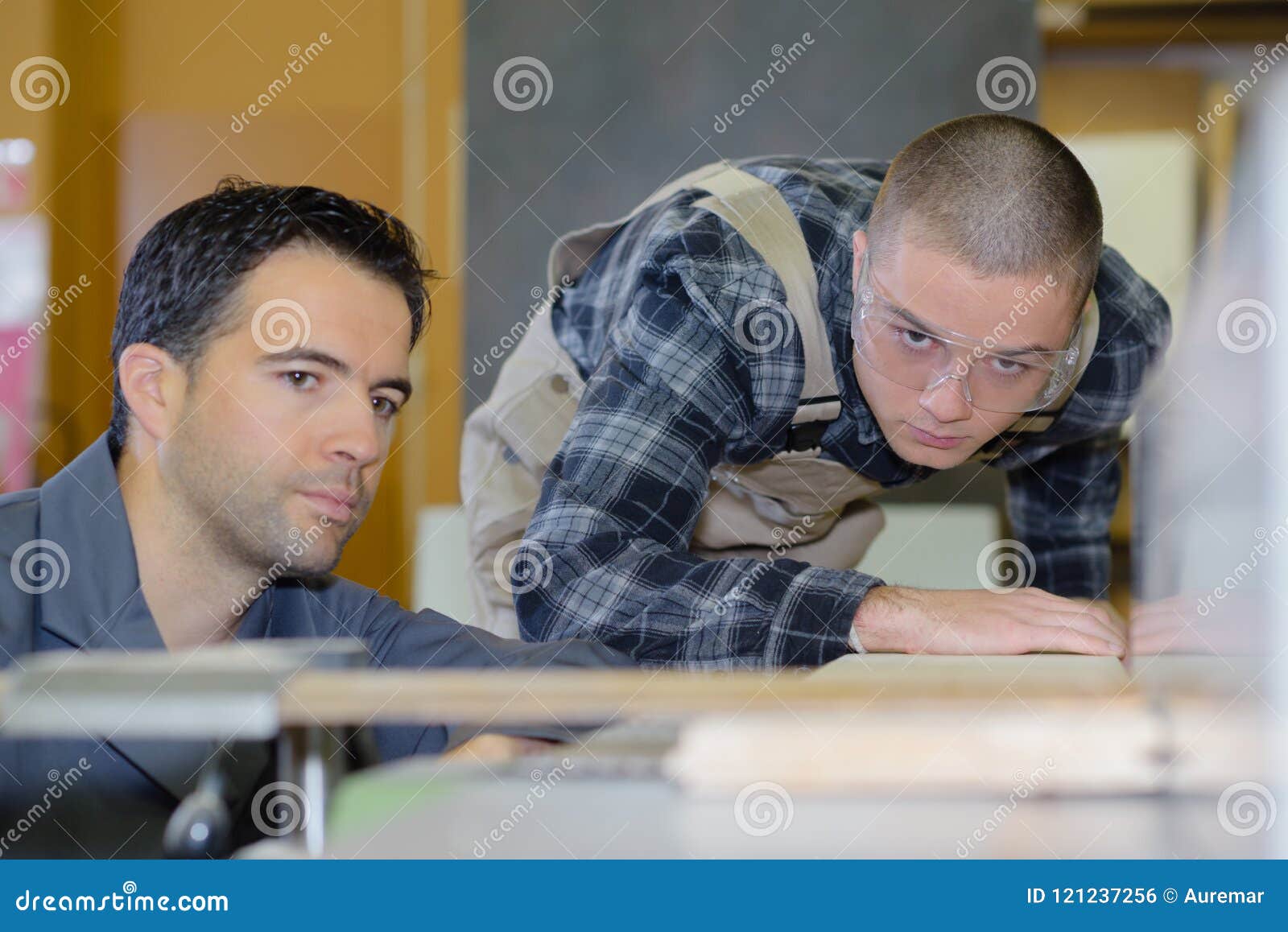 Carpenter with Apprentice Looking at Plans in Workshop Stock Photo ...