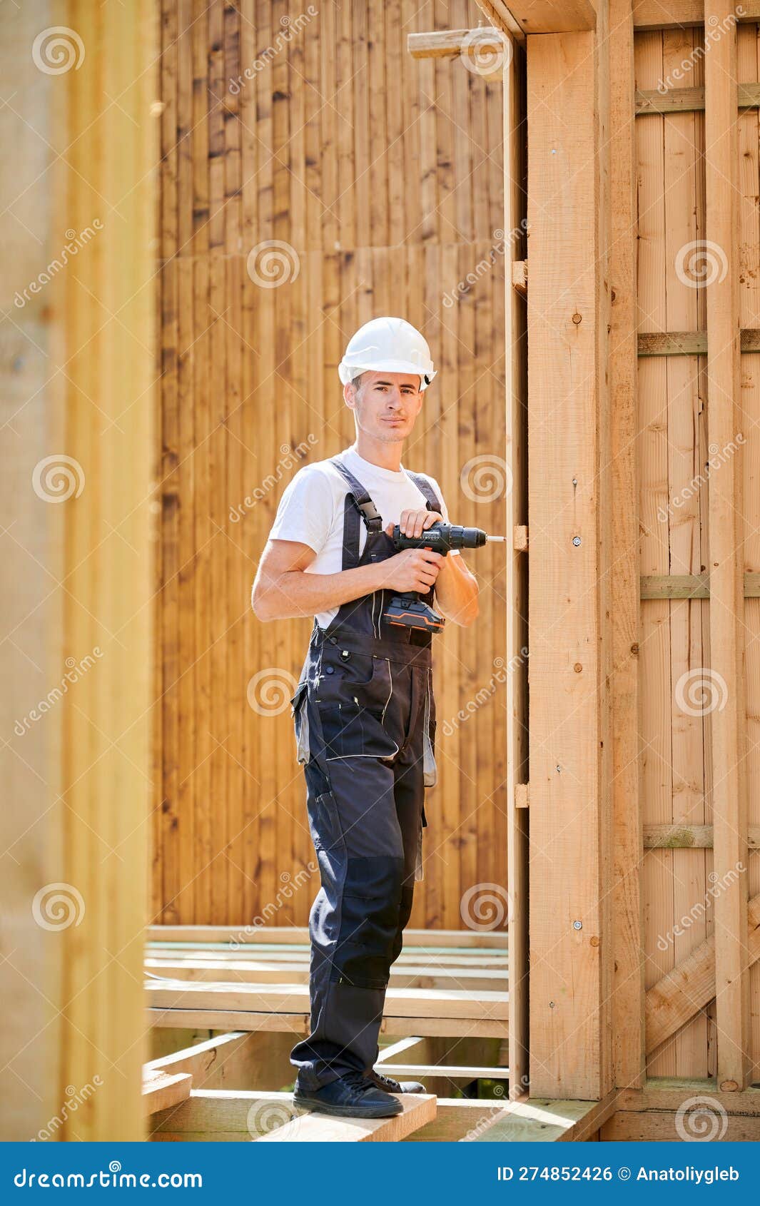 Carpenter Working with Screwdriver while Constructing Wooden Framed ...