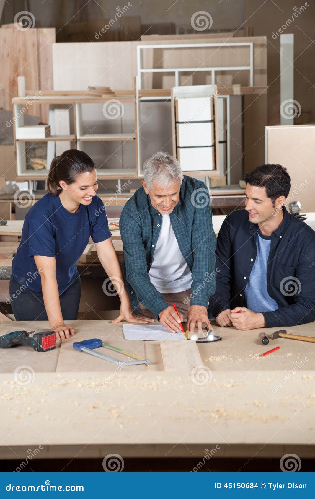 Carpenter Drawing Blueprint with Team at Workbench Stock Photo - Image ...