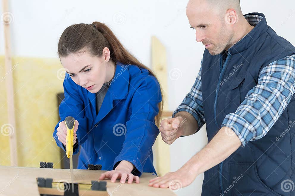 Carpenter with Female Apprentice Working on Building Site Stock Photo ...