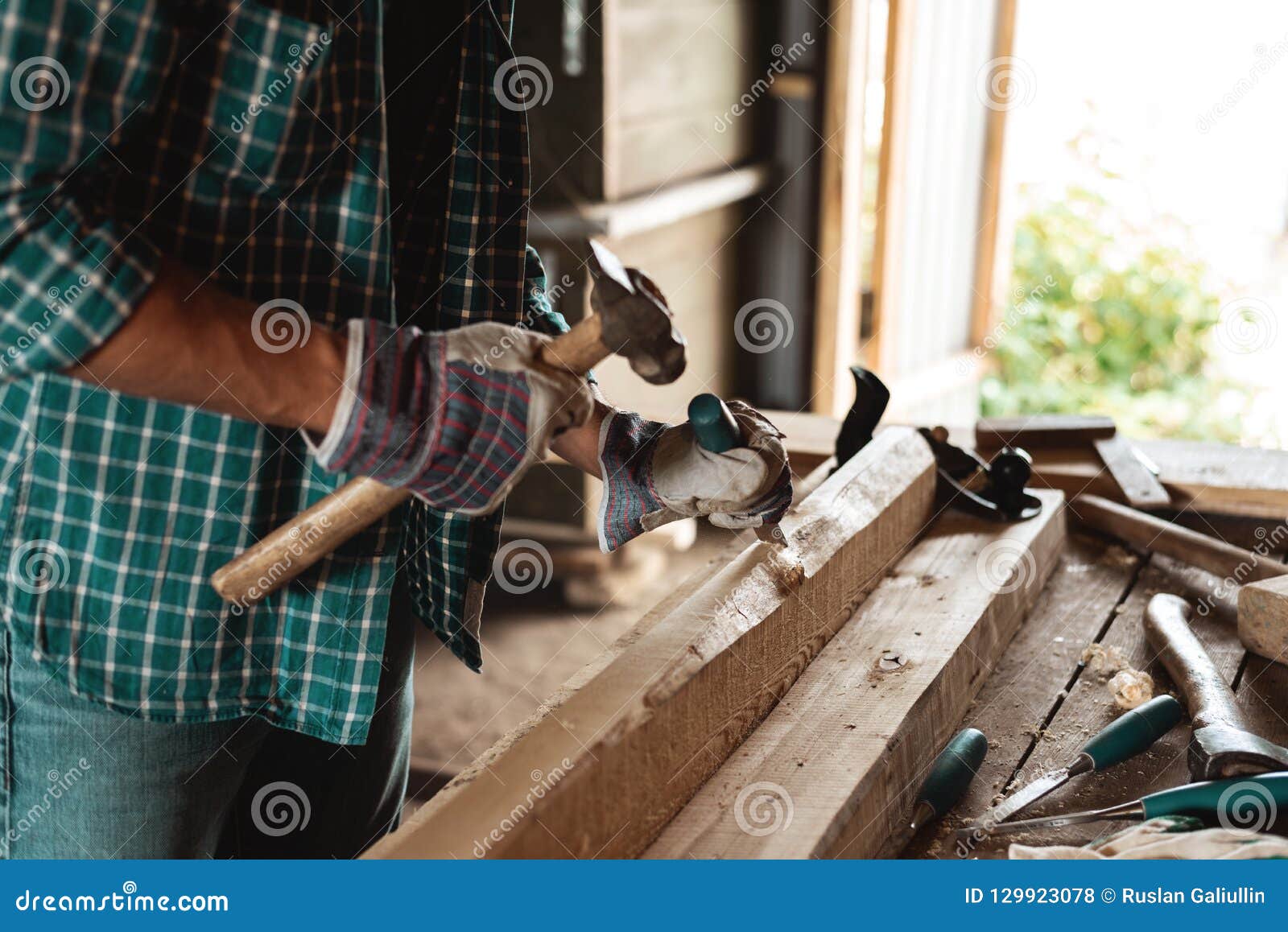Carpenter with a Hammer and Chisel Handles Wood. Joiner at Work in the ...