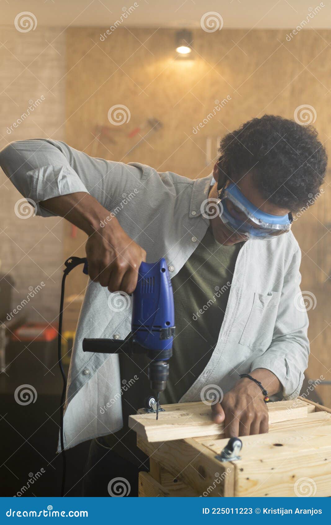 Carpenter with Safety Goggles Using Drill in Workshop Stock Image ...