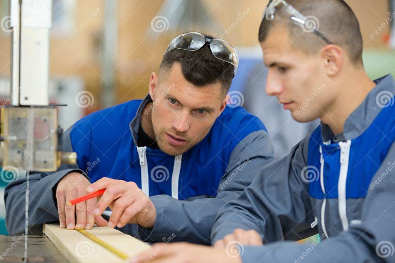 Carpenter Showing Apprentice How To Use Sawing Machine Stock Image ...