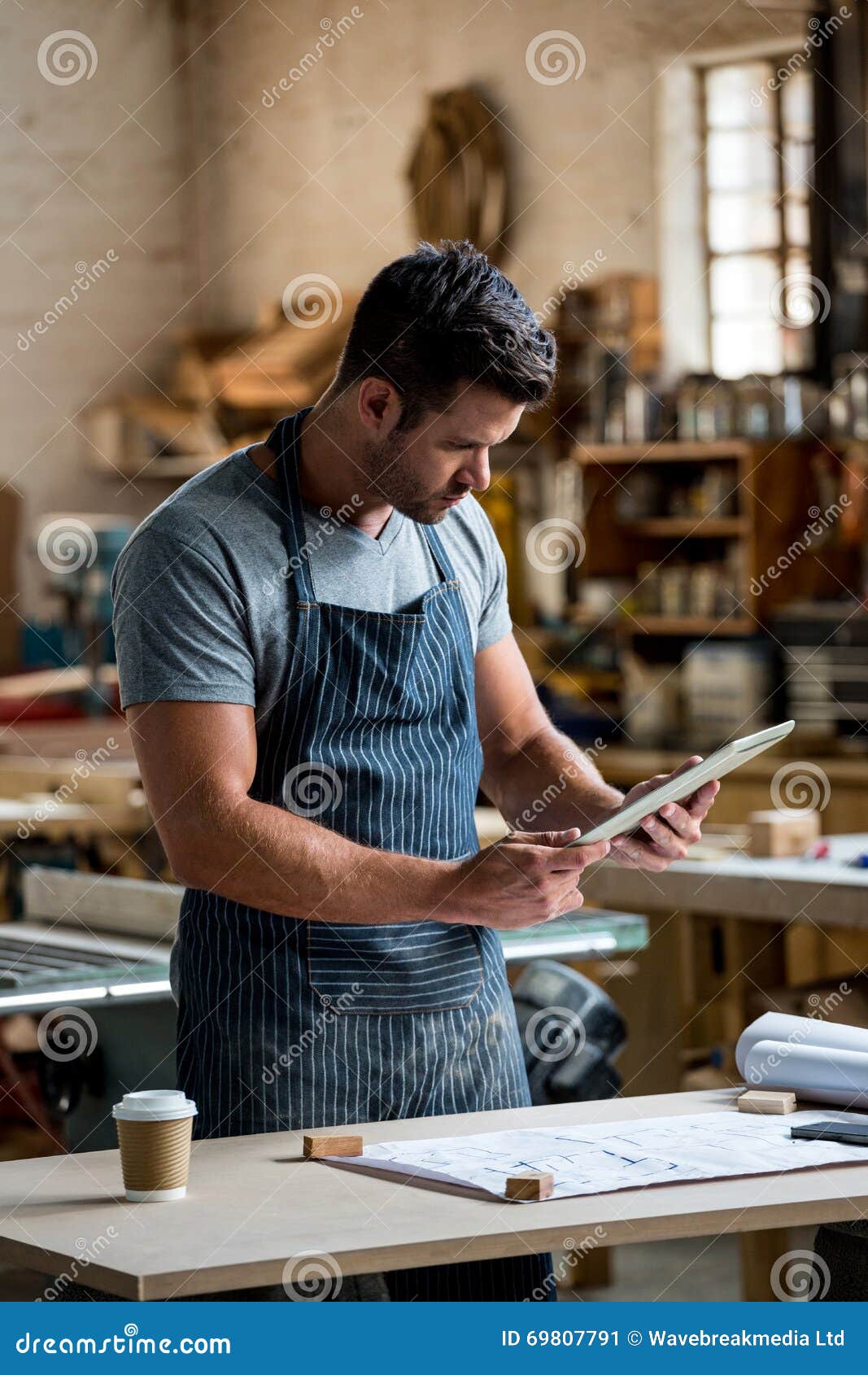 Carpenter using his tablet stock image. Image of people - 69807791