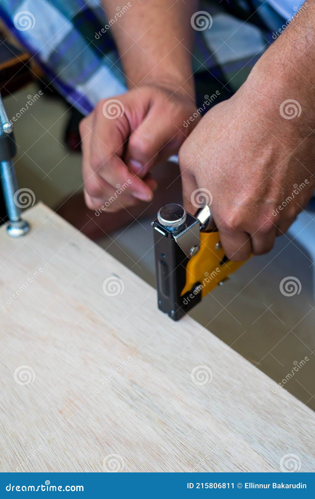 Carpenter Using an Industrial Construction Stapler on a Wood Plank ...