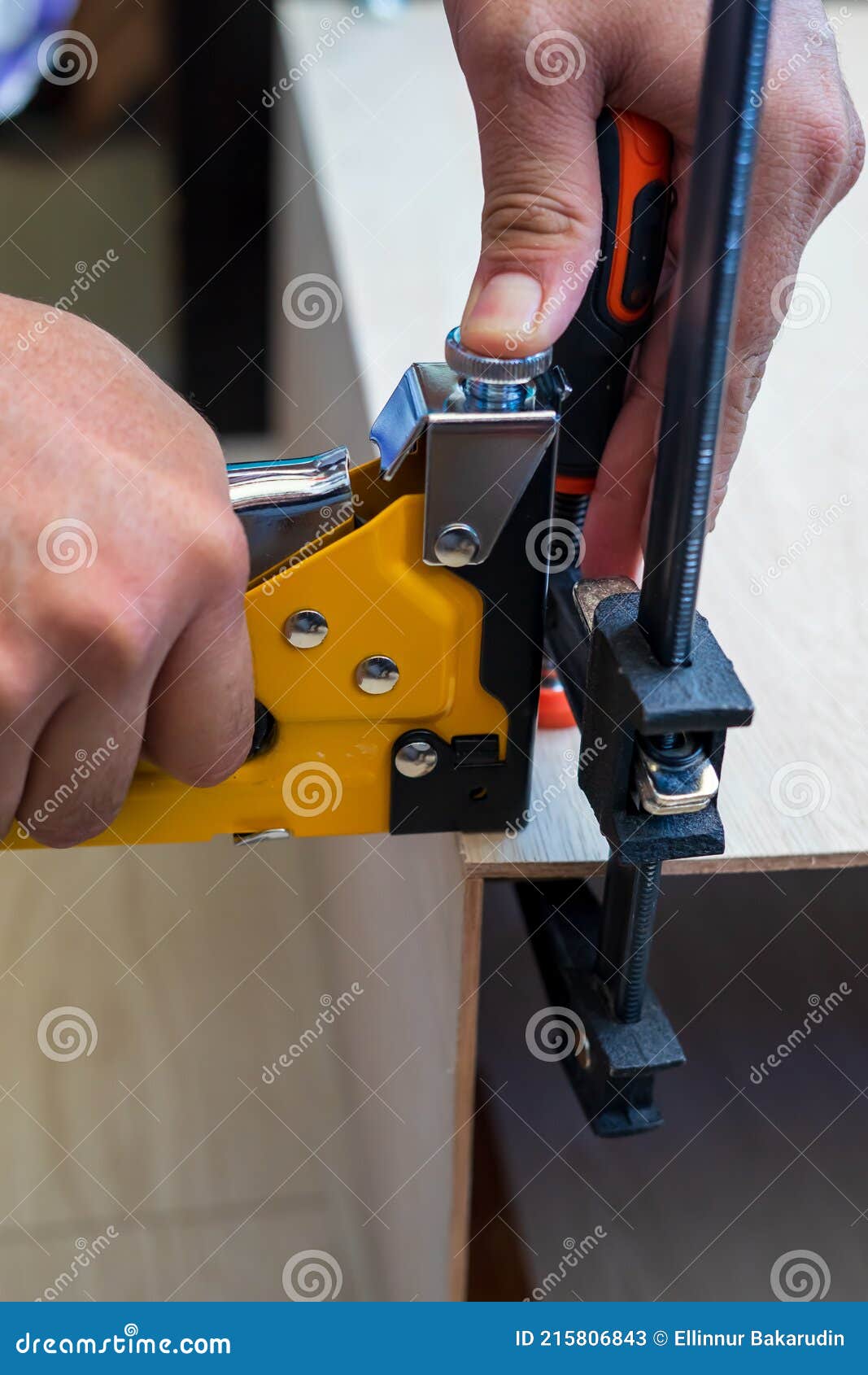 Carpenter Using an Industrial Construction Stapler on a Wood Plank ...
