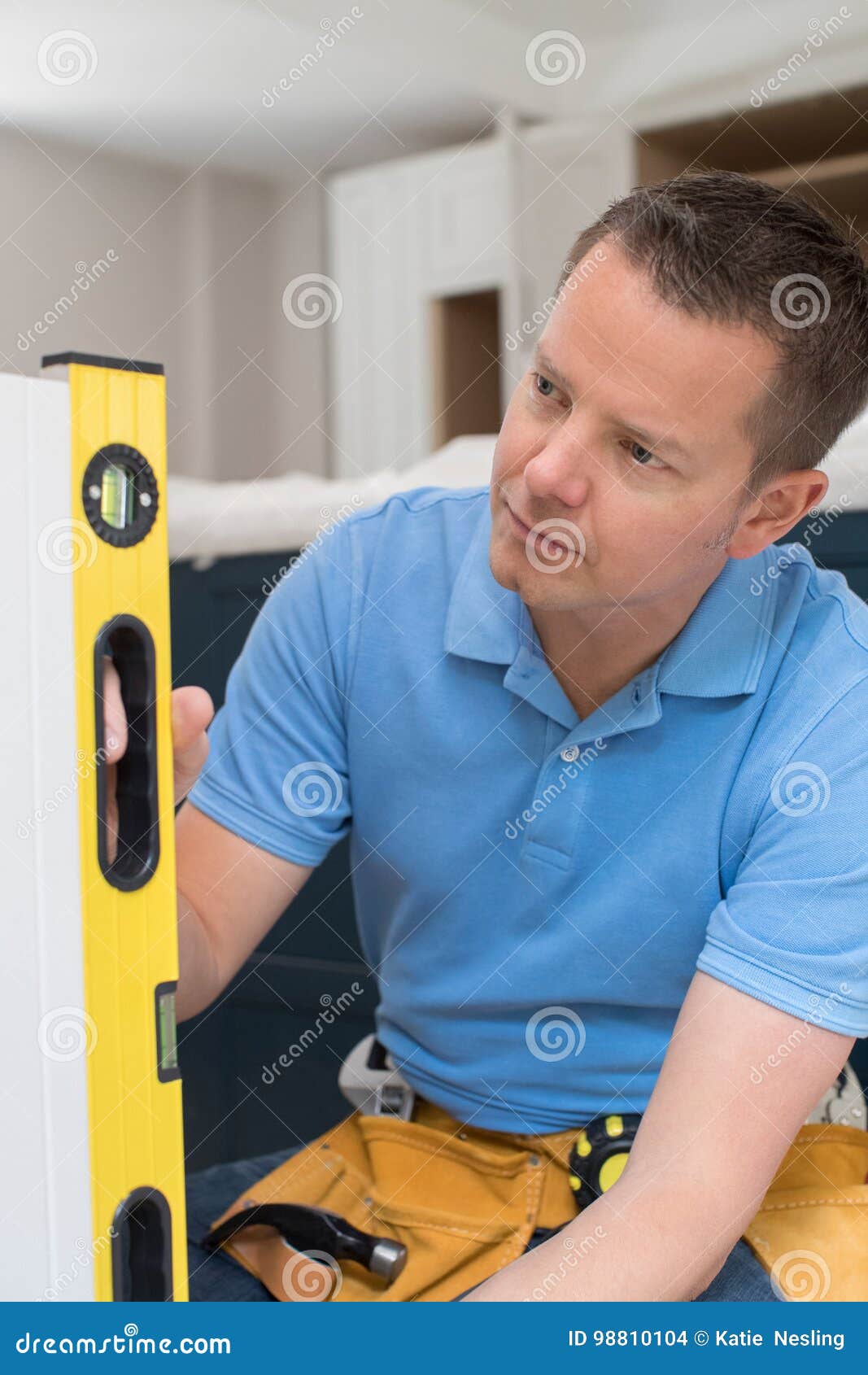 Carpenter Using Spirit Level Installing Luxury Fitted Kitchen Stock ...