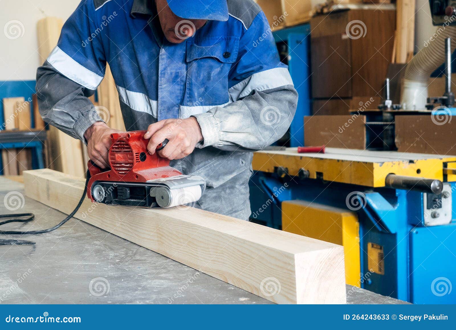 Carpenter in Work Clothes Processes Wood with Grinder. Polishing of ...