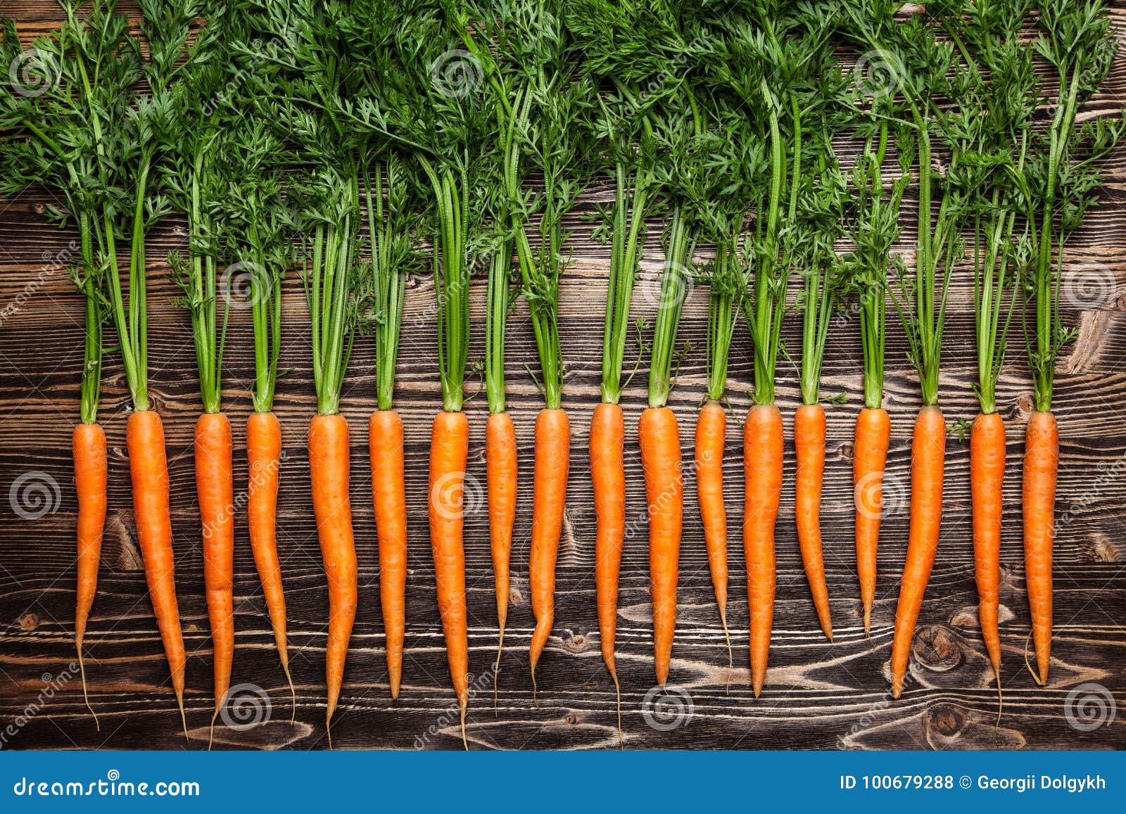 Carrot on wooden table stock photo. Image of bunch, food - 100679288