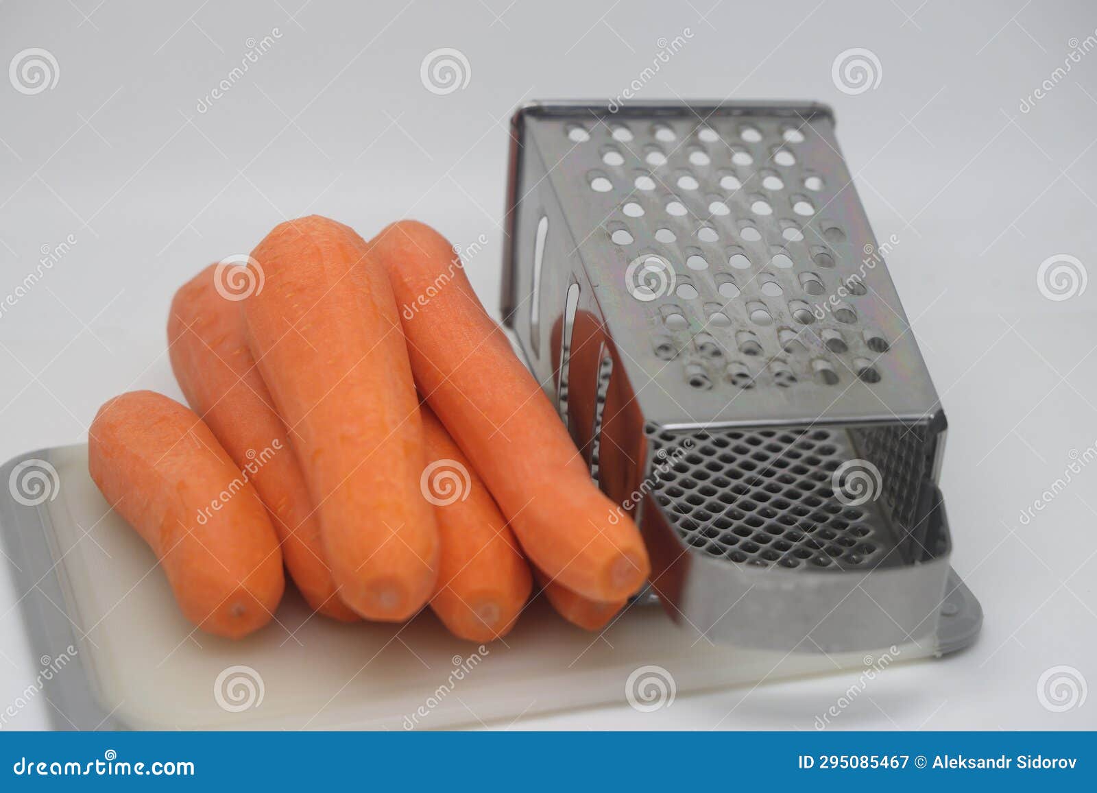 Carrots and Grater on a White Background, Close-up. Grated Carrots ...