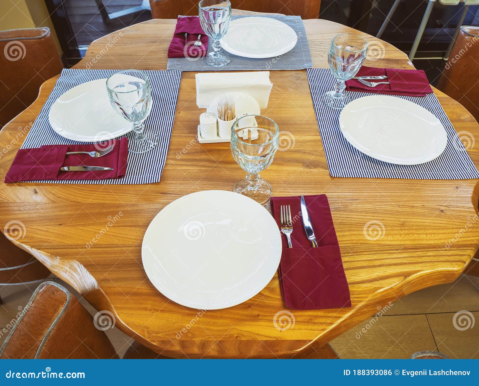 Carved Round Table with Crystal Glasses, Plates, Napkins and Silverware ...