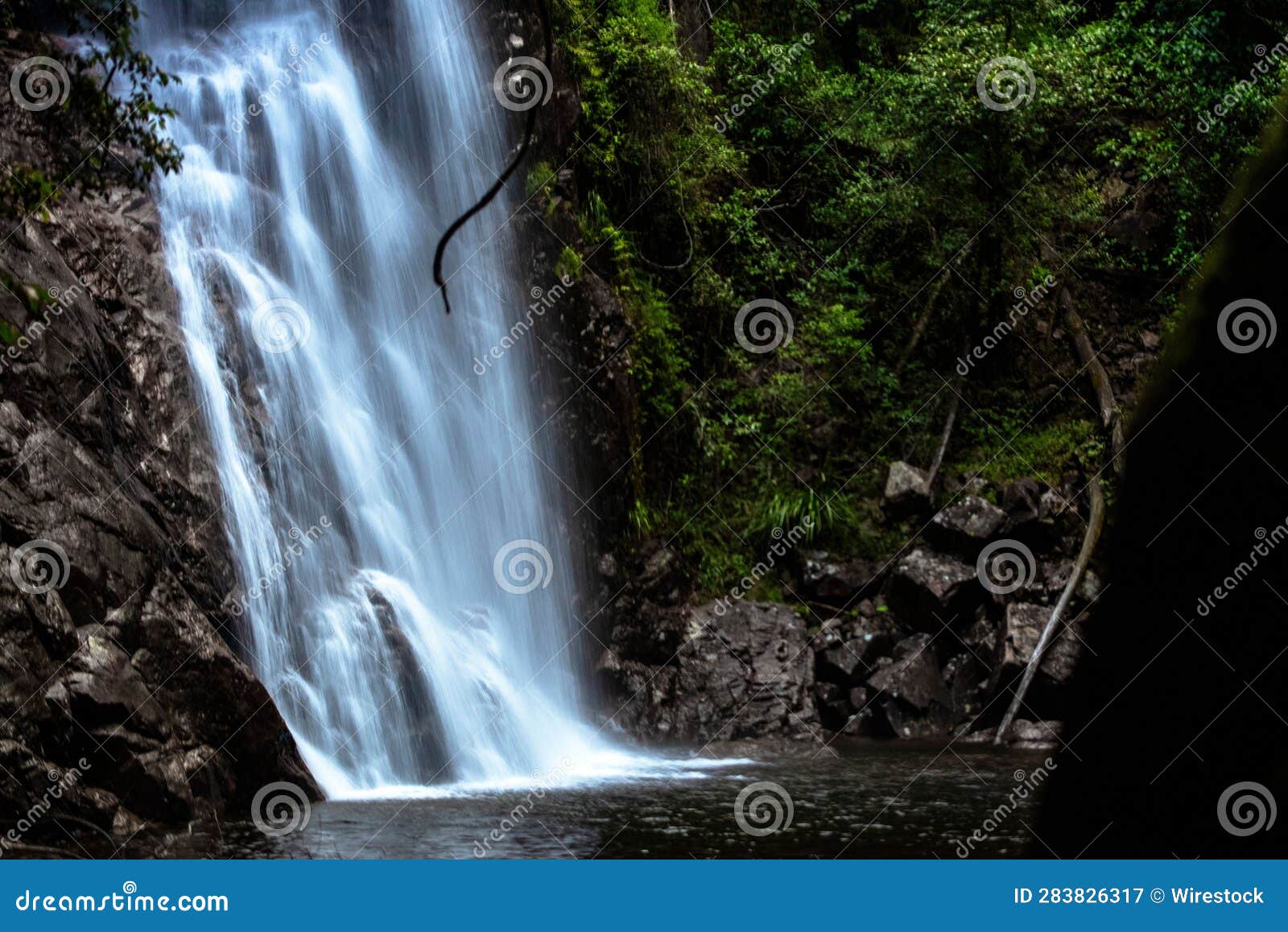 Cascading Waterfall Over a Rocky Riverbed Below Stock Image - Image of ...