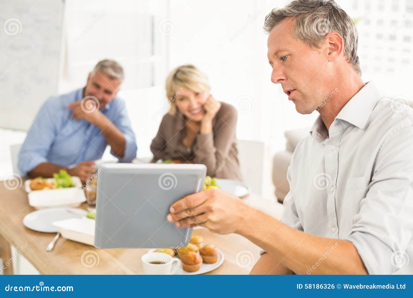 Casual Business People Looking at Tablet while Lunch Stock Photo ...