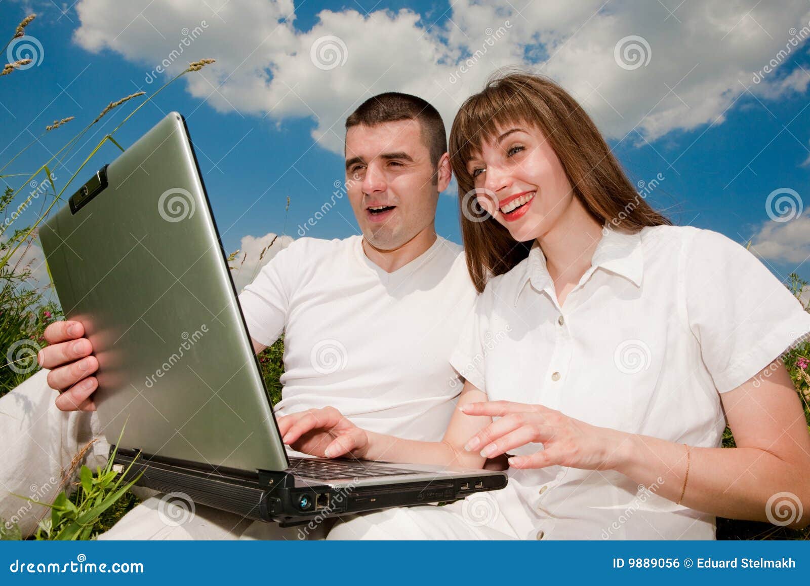 Casual Happy Couple on a Laptop Computer Outdoors Stock Photo - Image ...