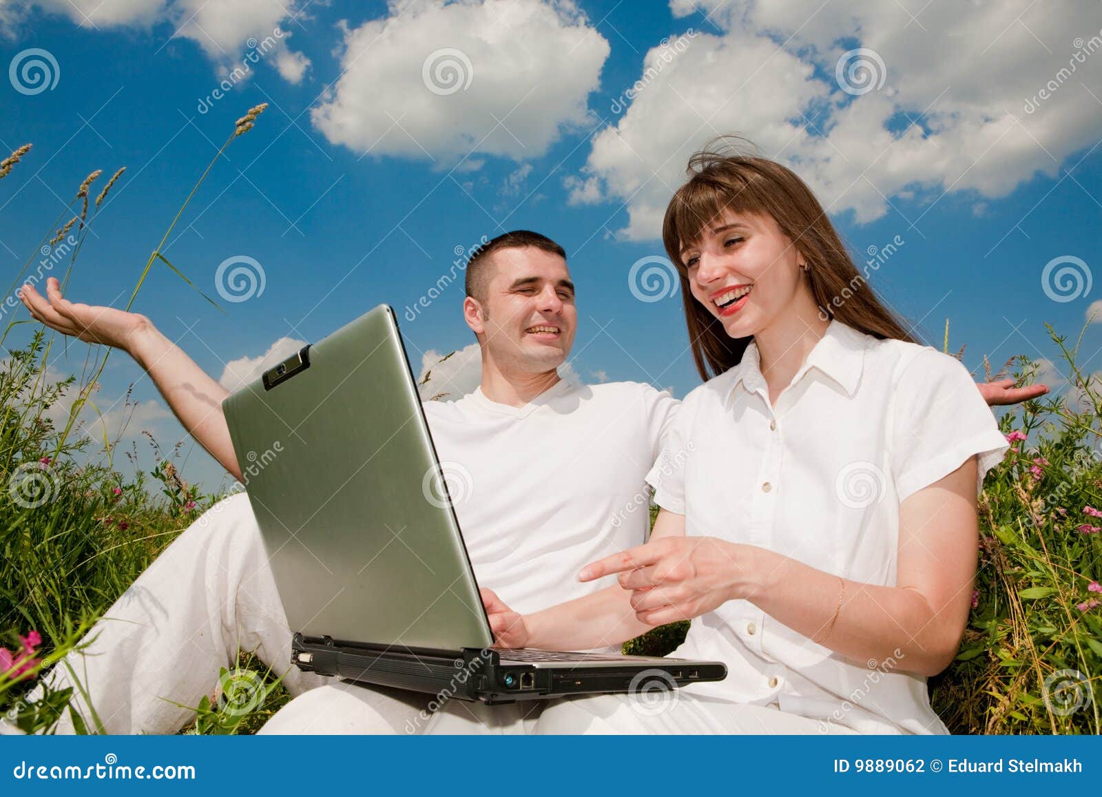 Casual Happy Couple on a Laptop Computer Outdoors Stock Photo - Image ...